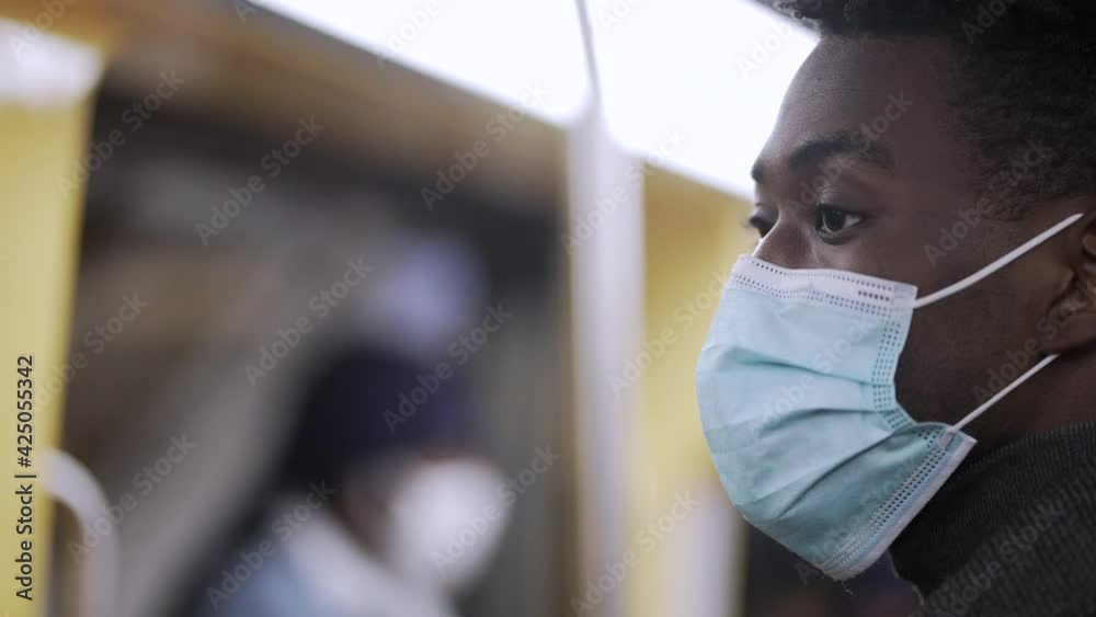 African man face close-up wearing covid-19 face mask inside public ...