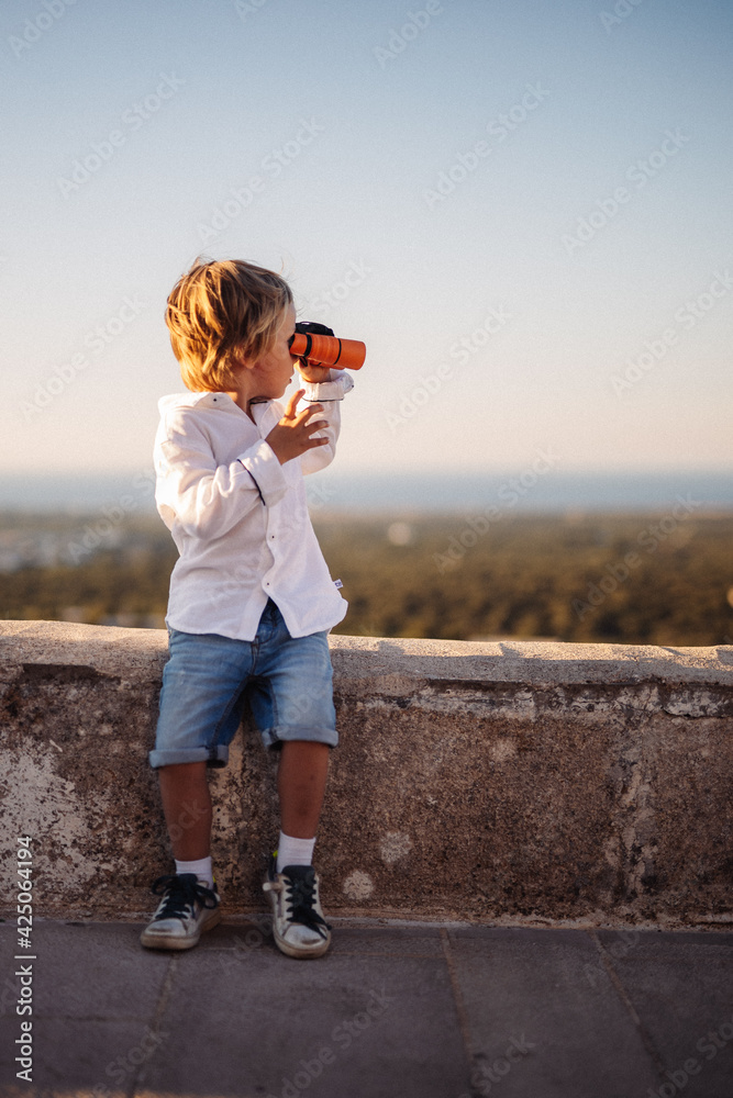 Foto de Jeune garçon observe avec ses jumelles belle vue en vacances en ...