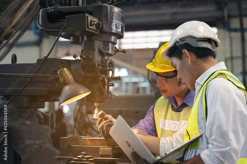 Two workers in production plant as team discussing, industrial scene in ...
