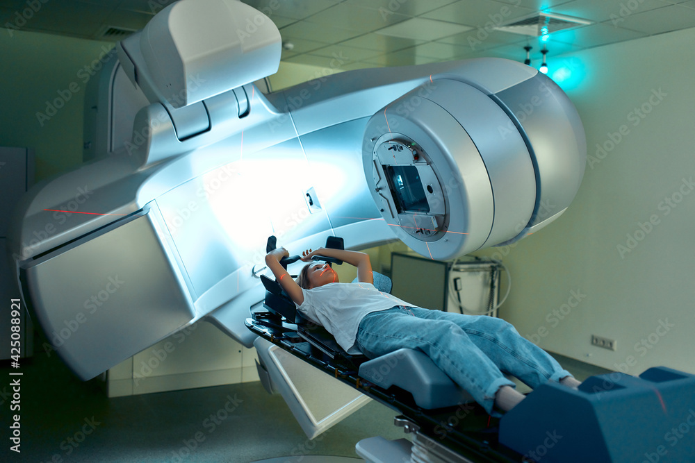 A young woman is undergoing radiation therapy for cancer in a modern ...