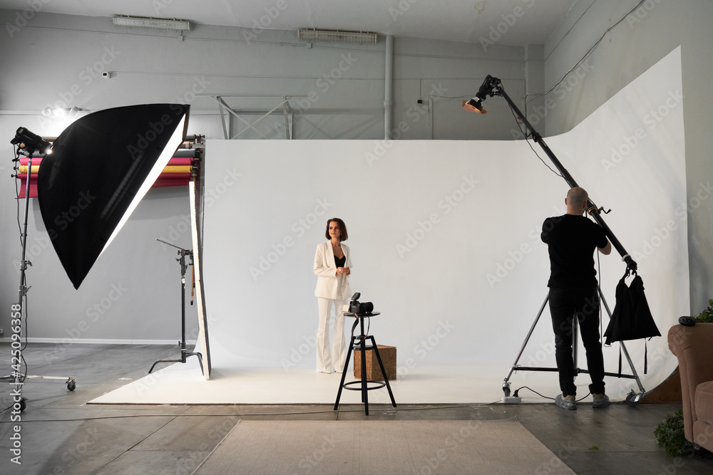 Fashion photography in a photo studio. Professional male photographer ...