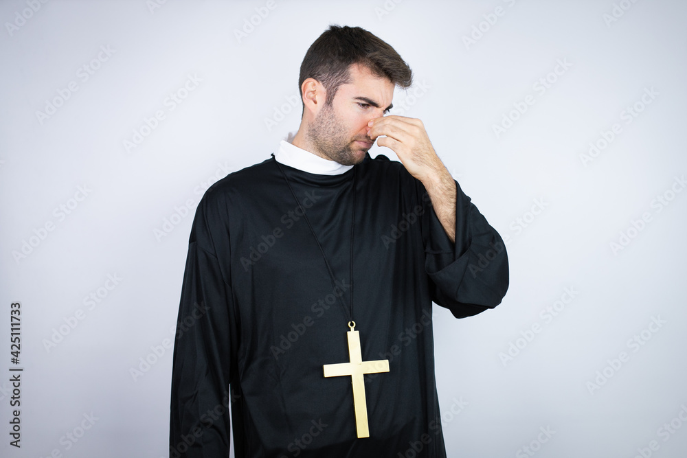 Young hispanic man wearing priest uniform standing over white ...