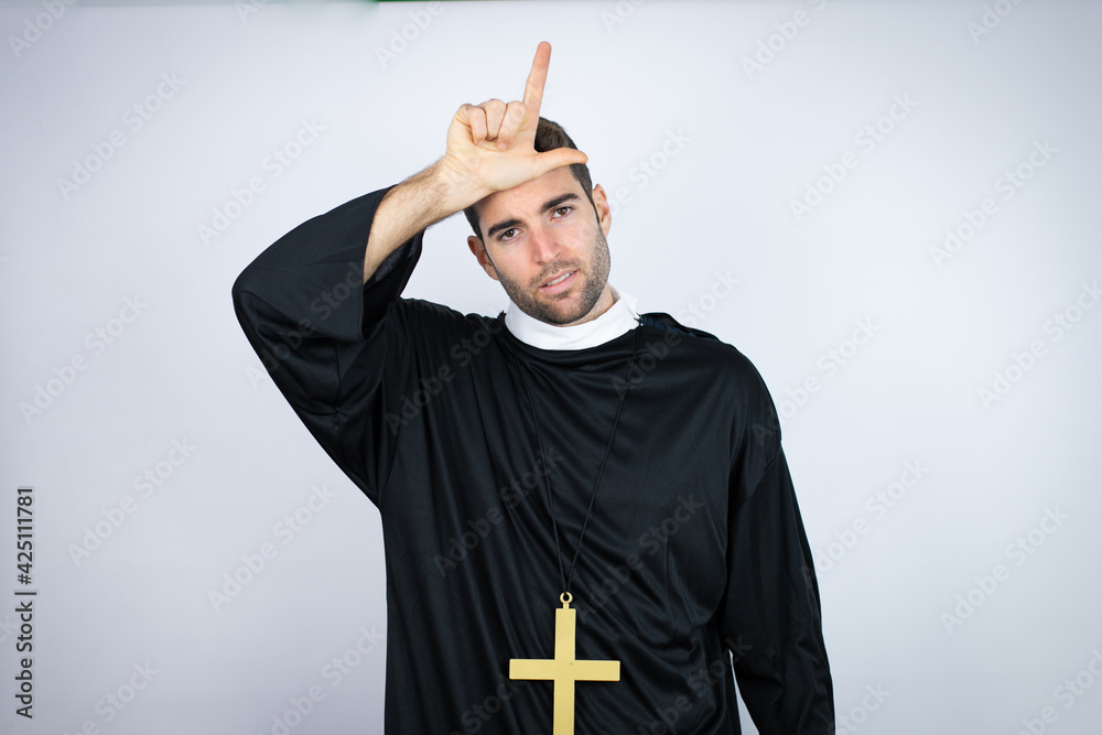 Young hispanic man wearing priest uniform standing over white ...