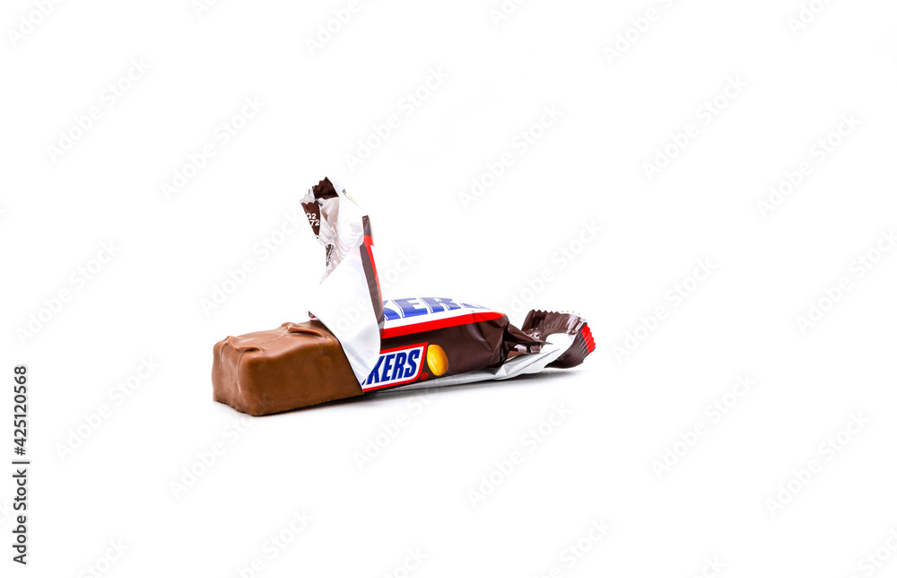 Snickers chocolate bar in a wrapper, half unfolded. Isolated chocolate ...
