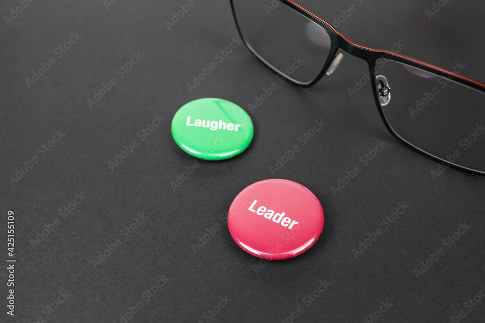 Colored plastic magnetic buttons on a black background next to glasses ...