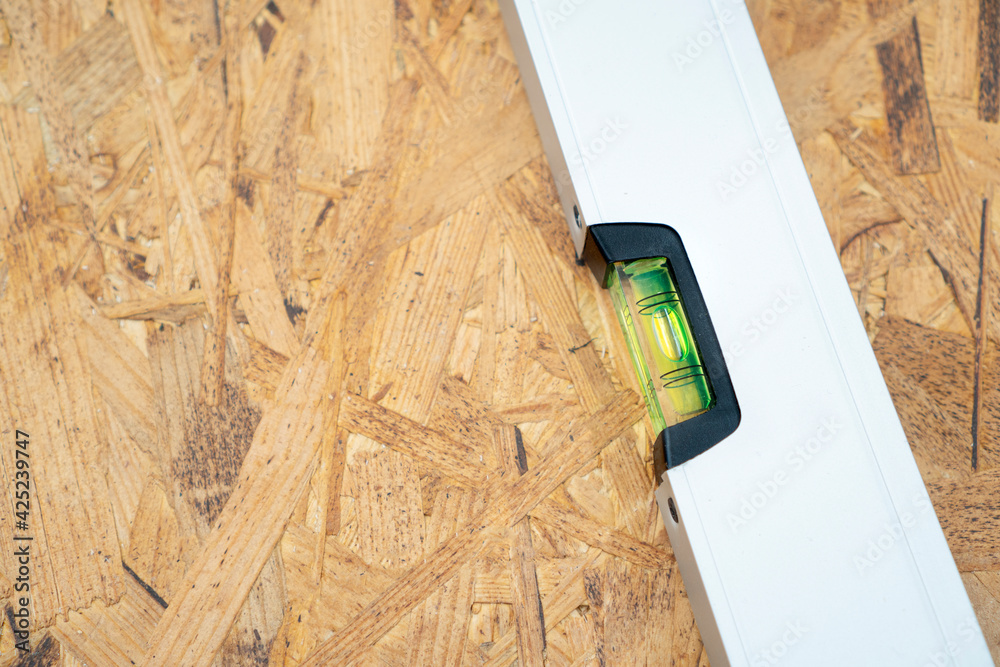 Water level tool lying on the OSB panel. Stock Photo | Adobe Stock