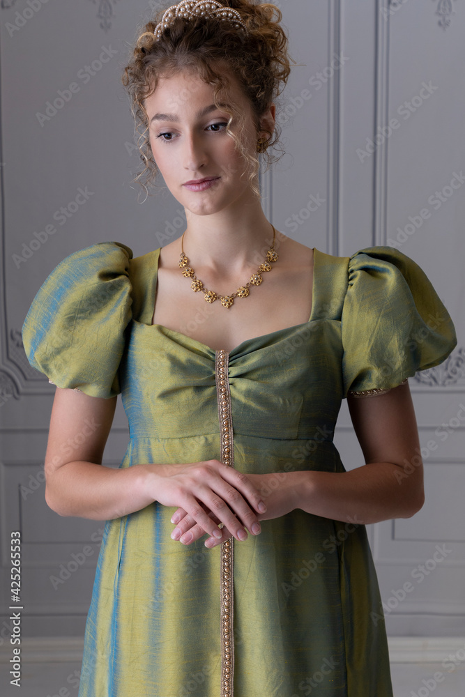 A young Regency woman wearing a green shot silk dress and shown from in ...