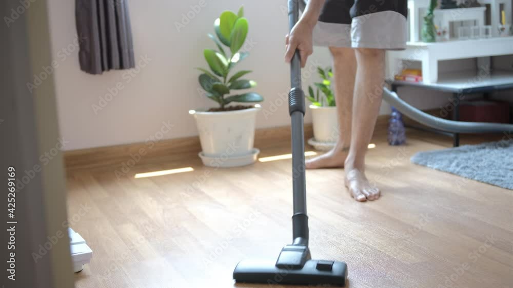 Asian male inspector with vacuum cleaner to cleaning staff in bathroom ...