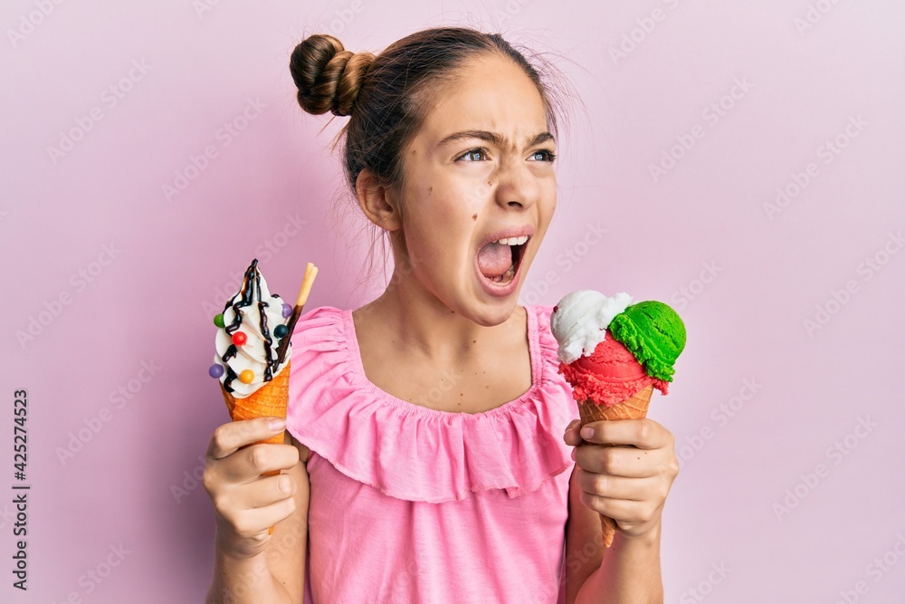 Beautiful brunette little girl eating ice cream cones angry and mad ...