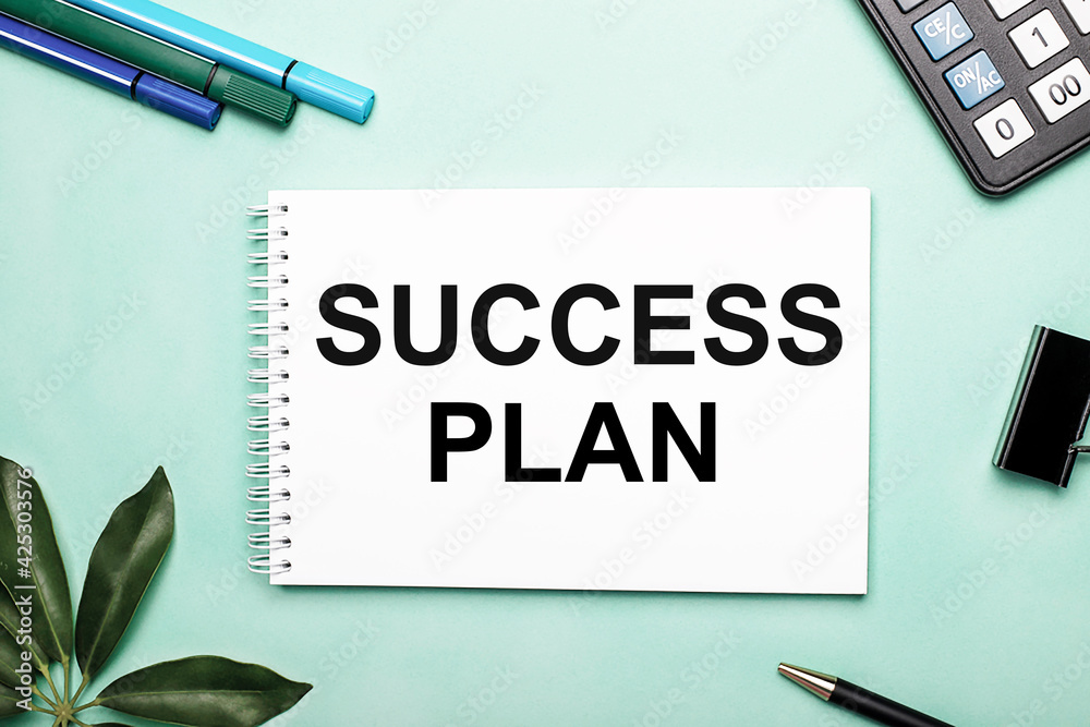 SUCCESS PLAN is written on a white sheet on a blue background near the ...