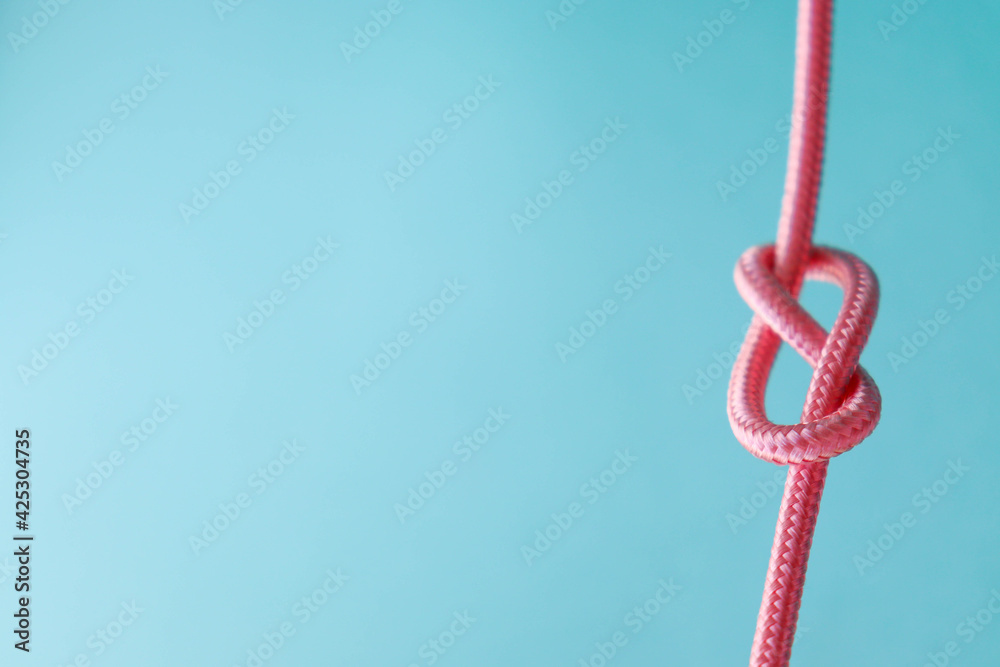 Blue background picture with a pink rope. A concept for tying the knot ...