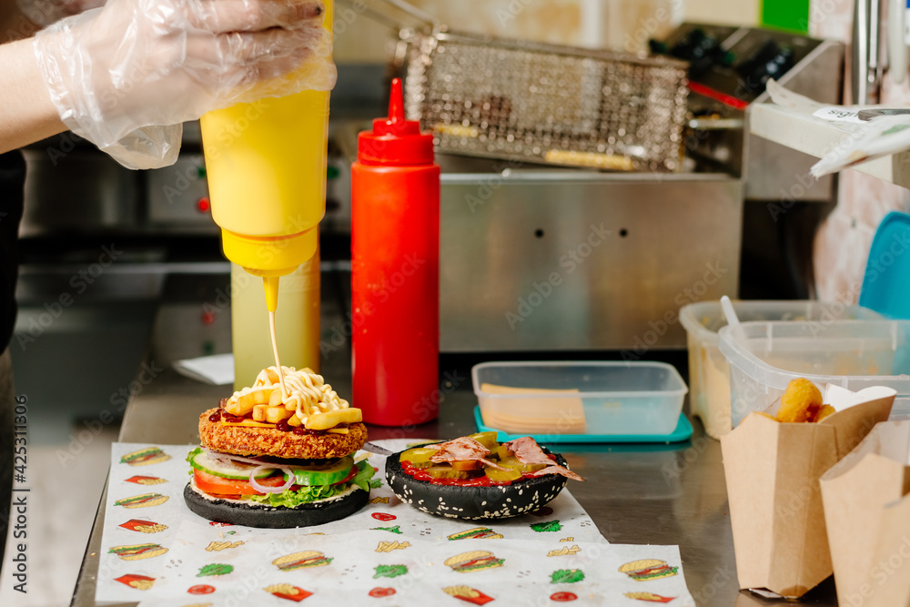 Foto de The process of making a chicken burger with fries in a black ...