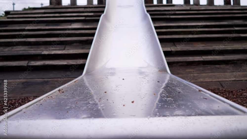 Looking up at the top of a metallic slide in a playground, symbol of ...