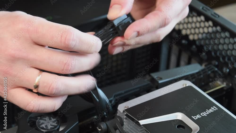 Male fingers hold power supply plugs of 12V ground 5V electric cables ...