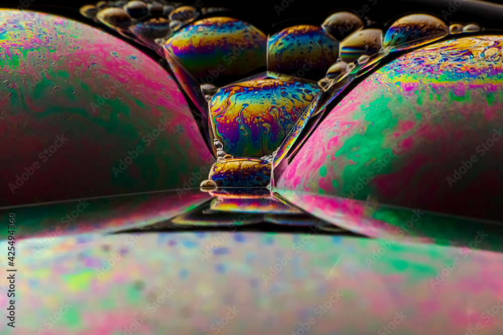 The colorful close-up surface of a soap bubble with weird psychedelic ...