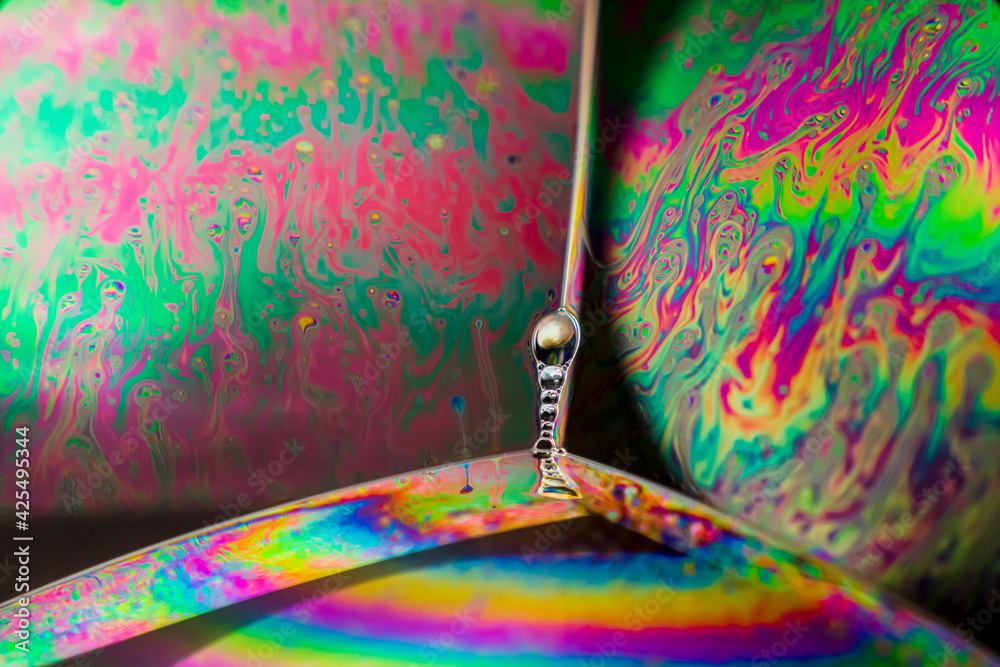 The colorful close-up surface of a soap bubble with weird psychedelic ...