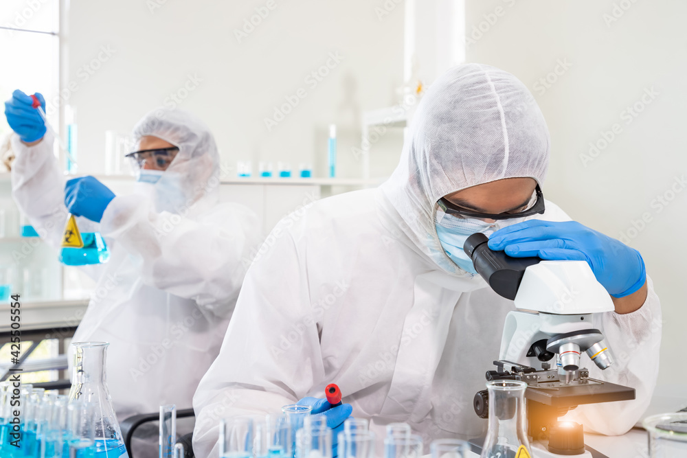 Researcher in laboratory personal protective equipment suit or PPE ...