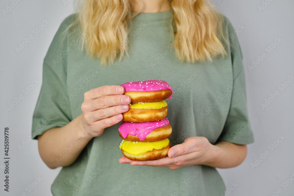 Colored doughnuts in the hands of a girl. Delicious sweet american ...