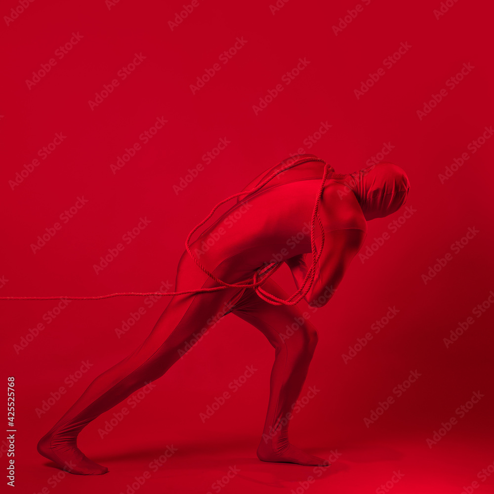 an anxious red man in a red leotard, dragging a heavy burden, Stock ...