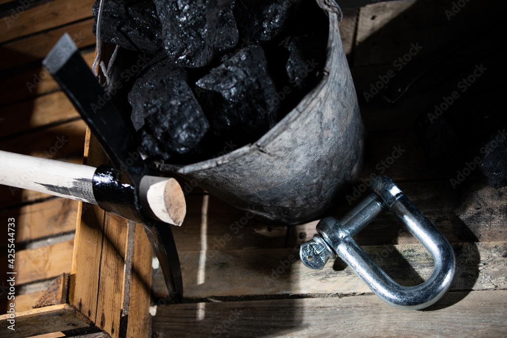 Large pickaxe with wooden handle on black background with lumps of ...