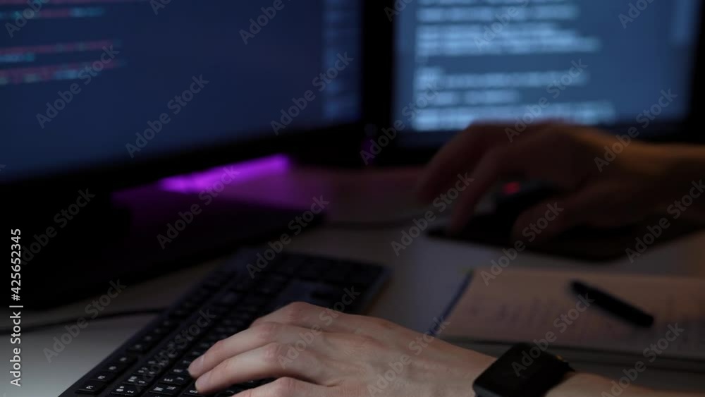 Young programmer works in front of computer typing on keyboard and ...