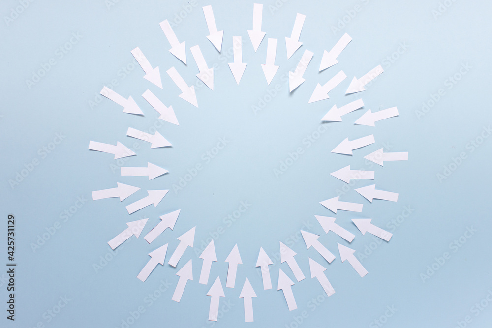 Circle made of many arrows pointing inwards on blue background. Photo ...