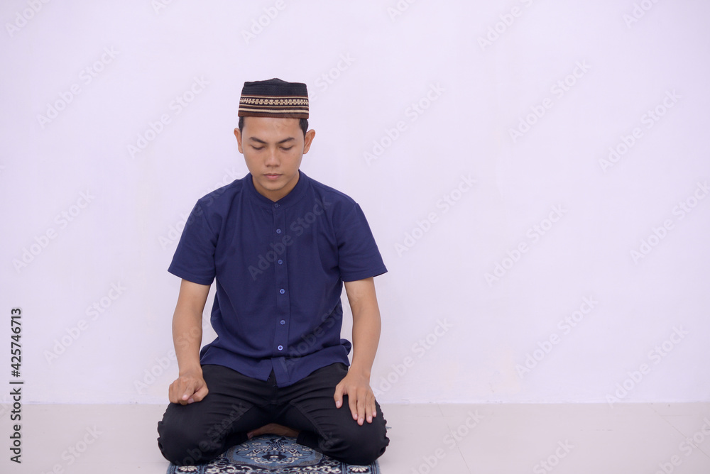 Religious muslim man praying in the mosque while wearing islamic ...