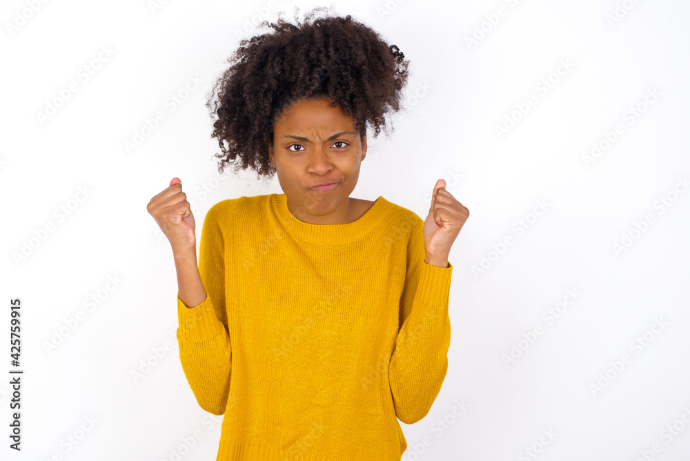 Irritated young beautiful African American woman wearing yellow sweater ...