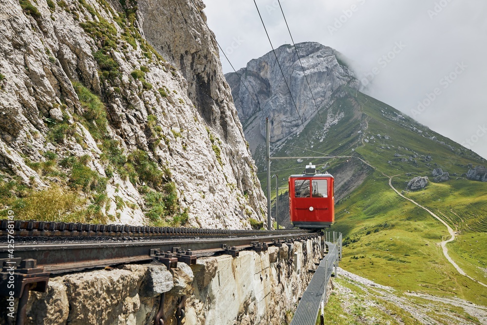 Cogwheel train passing mountain landscape of Swiss Alps.Red train on ...