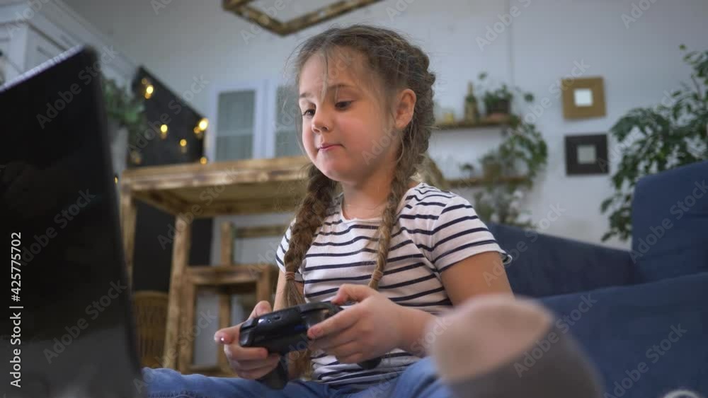 Vidéo Stock Happy girl playing video games with a joystick. Child ...