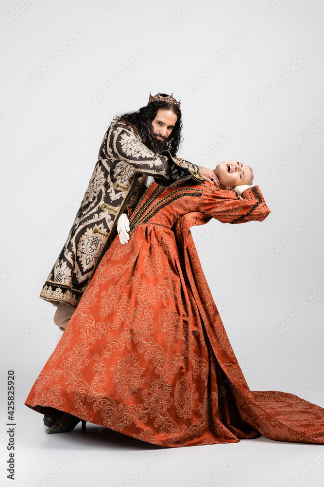 full length of cruel hispanic king in medieval clothing choking shocked ...