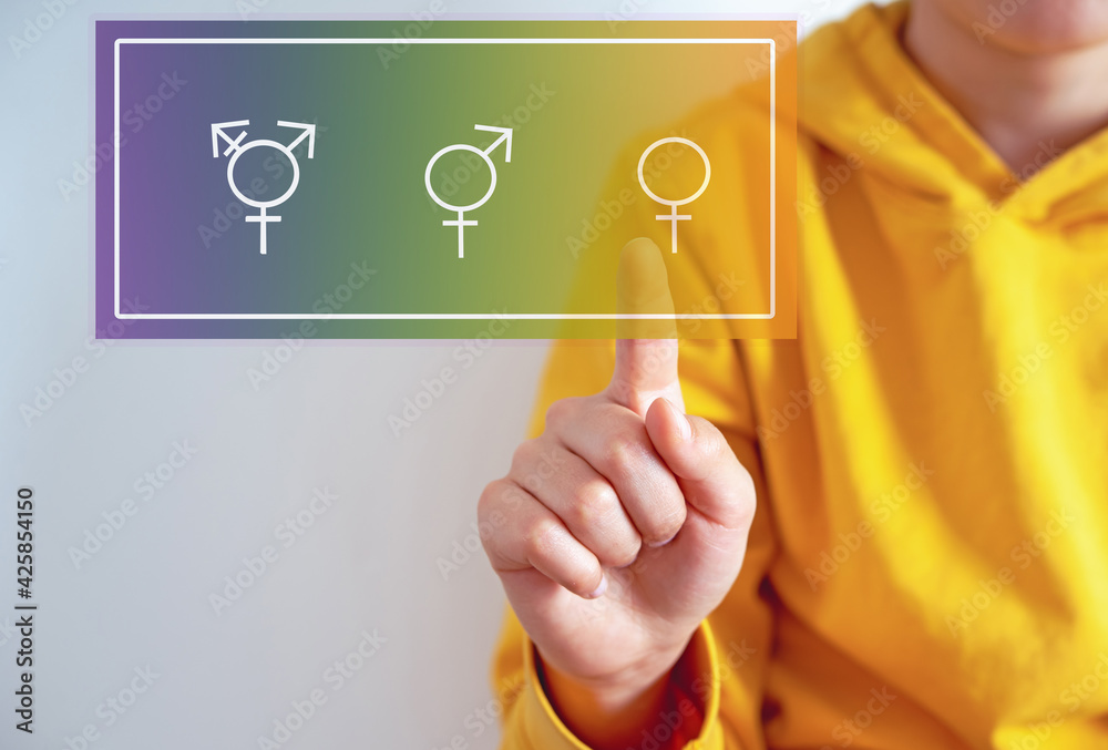 Gender confusion in teenager. A teen boy pointing at gender symbols of ...