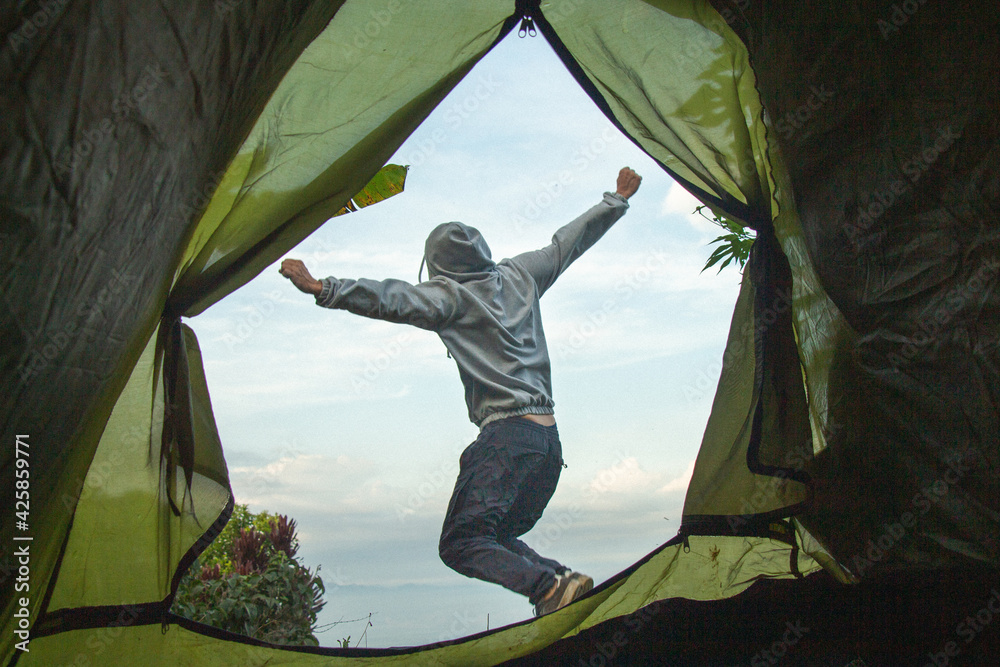 Hombre acampando en una carpa y dando un salto de alegría fuera de su ...