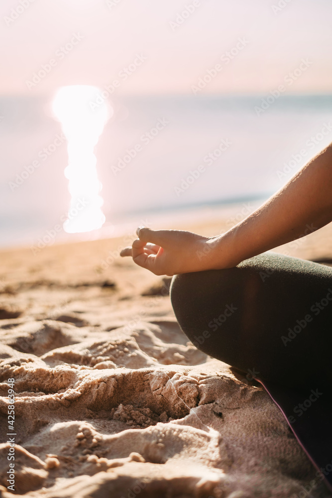 Vertical Yoga background. The girl sits on the beach by the sea in the ...