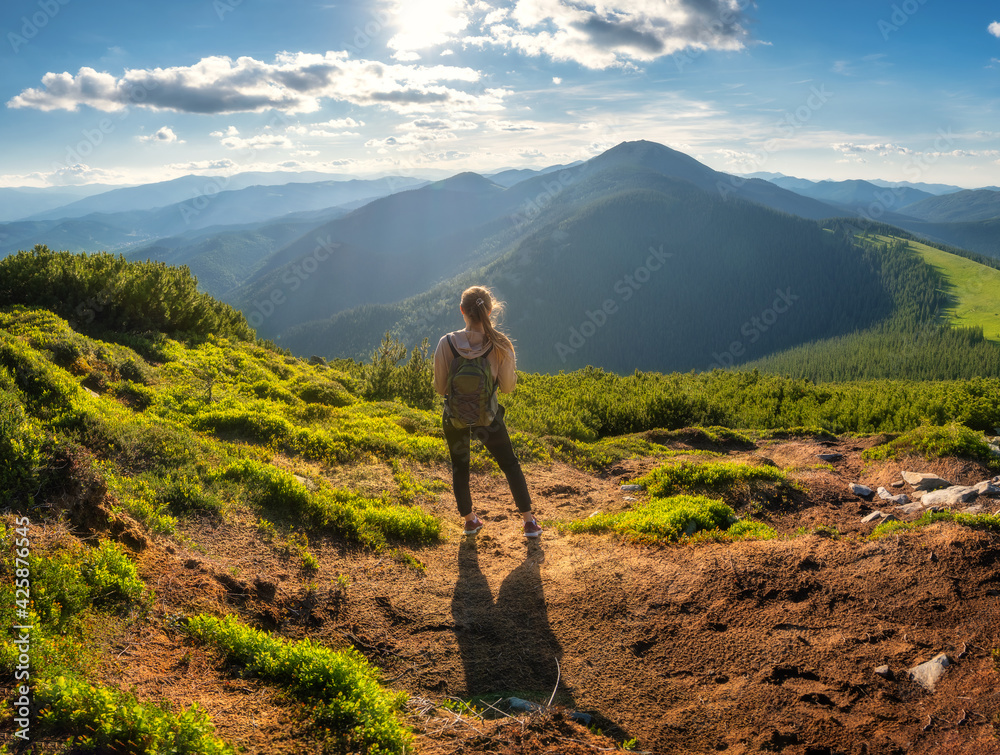 Girl on mountain peak with green grass looking at beautiful mountain ...