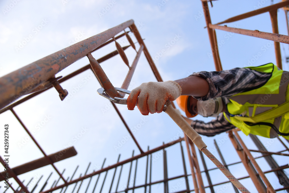 Construction workers hook up safety belts At construction working ...