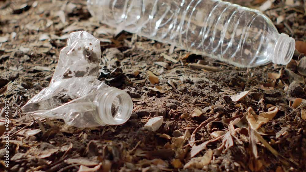 Close up - Plastic bottle thrown away next to another bottle left on ...