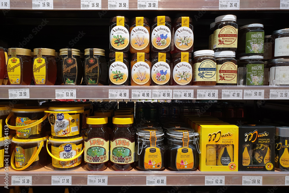 Various brands imported pure honey on store shelf. Honey is a sweet ...