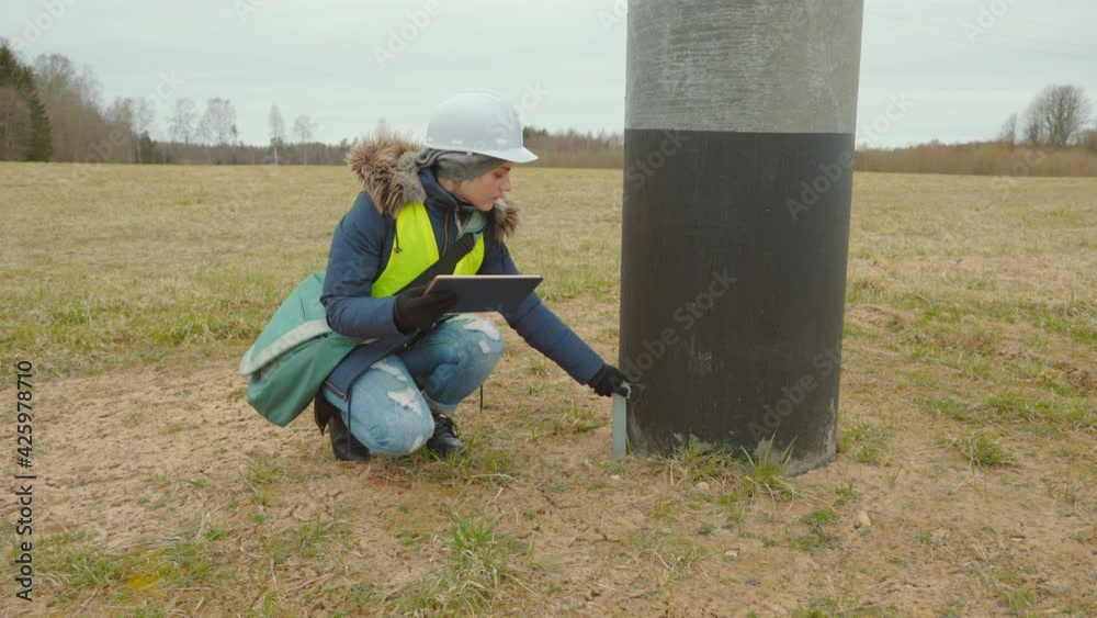Woman electrical engineer inspecting electric utility grounding for ...