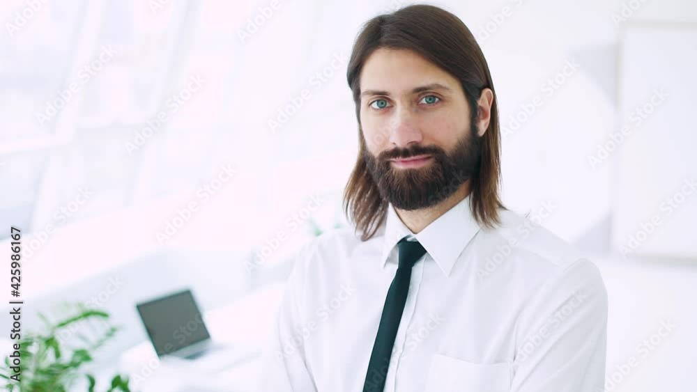 portrait of a young business man in a white shirt and tie looking ...