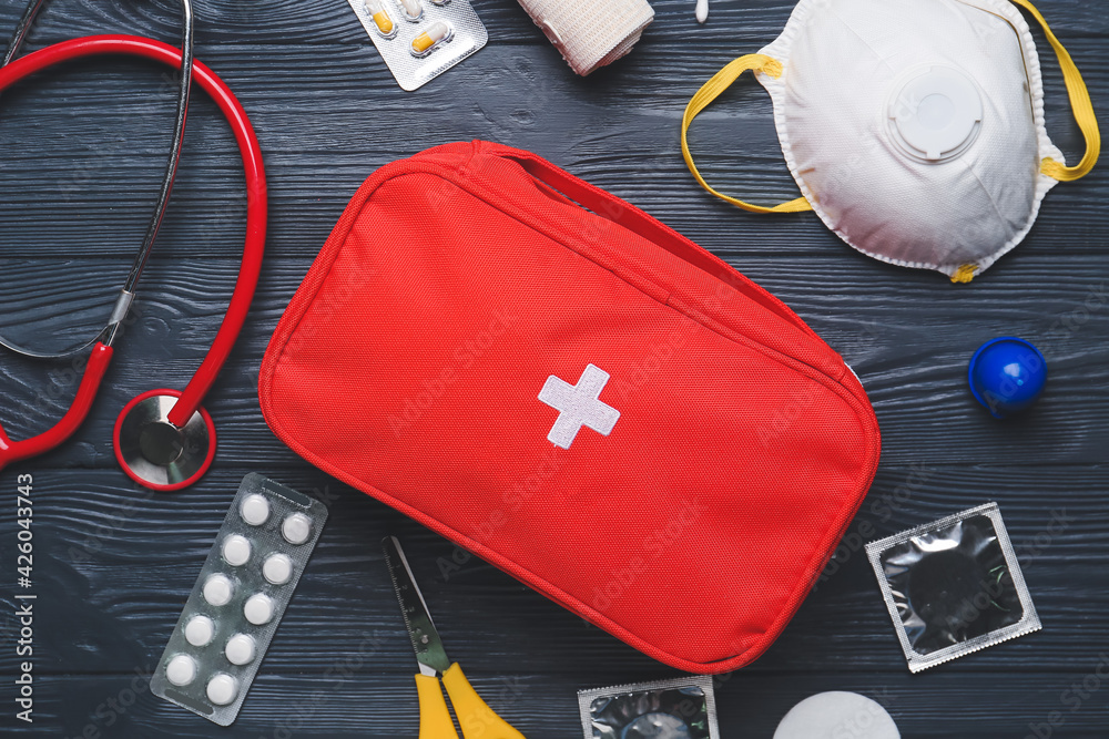 First aid kit on dark wooden background Stock Photo | Adobe Stock