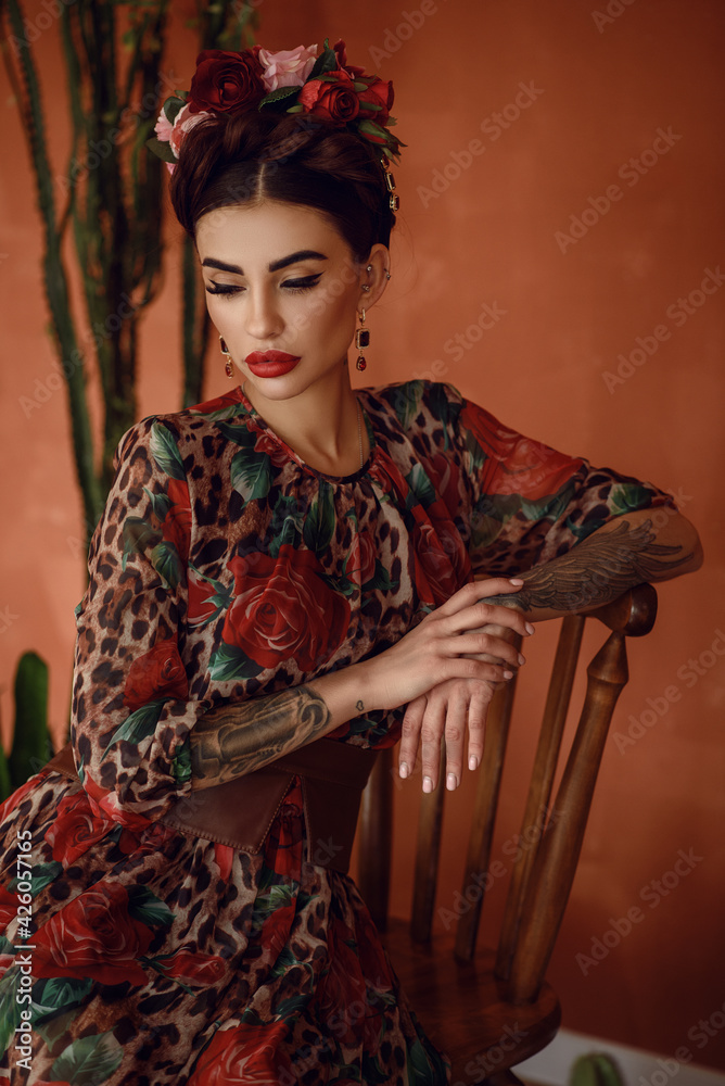 Portrait of beautiful dark-haired tattooed woman with crown braid ...