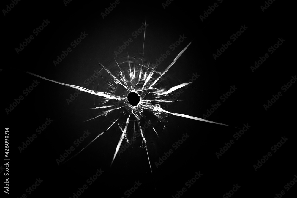 Cracked texture on a black background. Broken glass bullet from a shot ...