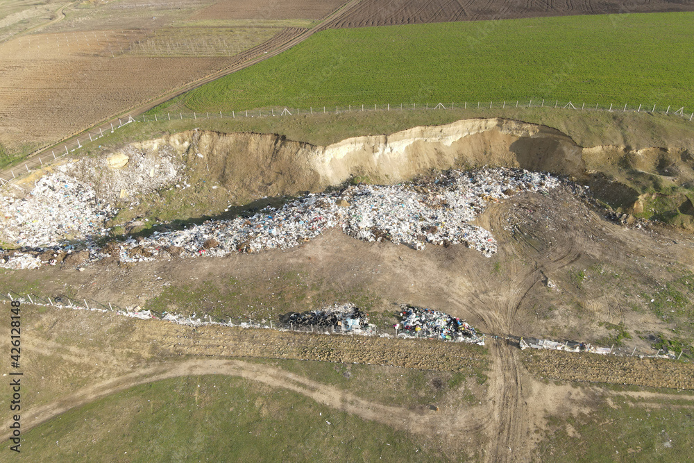 a dump landfill located near the wheat plantation, dumping waste in the ...