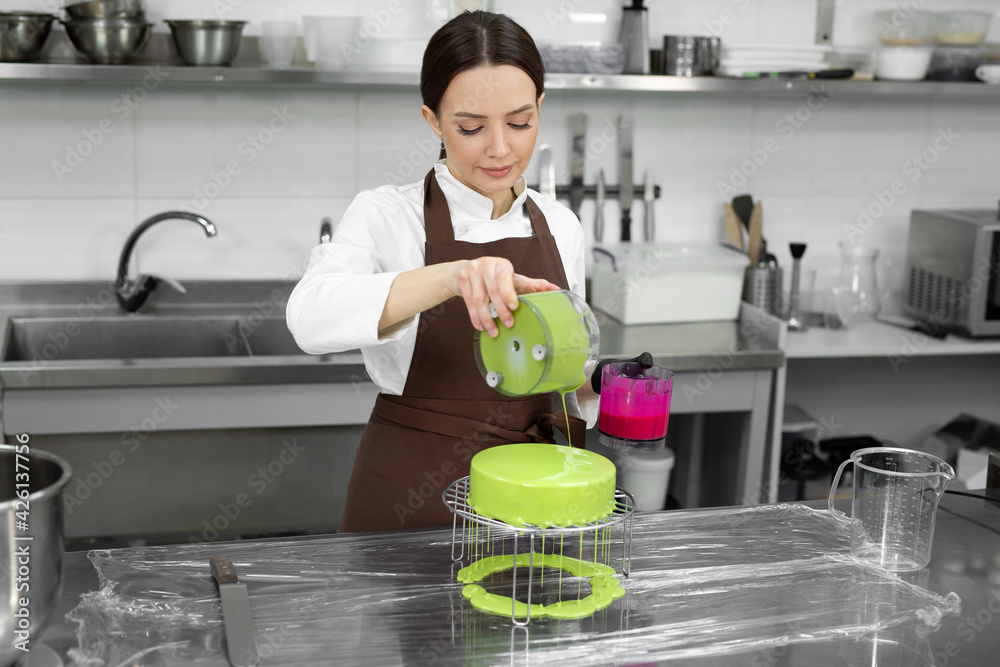 Female pastry chef decorates a mousse cake with a mirror glaze. Stock ...