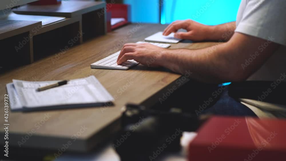 Creative person sitting at his home office modern wood desk typing on a ...
