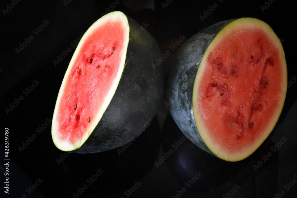 Juicy ripe watermelon is cut on cubes and laid out on a white plate. In ...