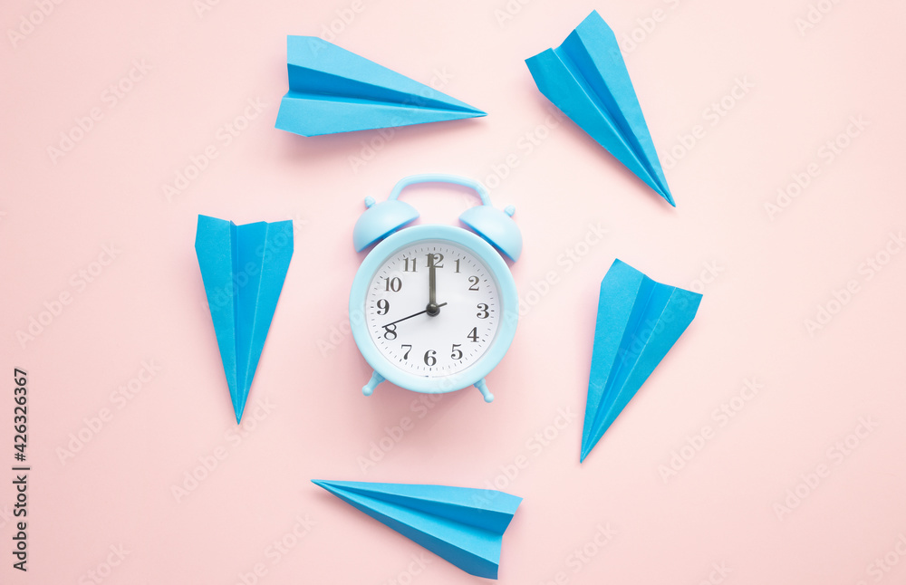 Time flying concept with blue paper airplanes and alarm clock on a pink ...
