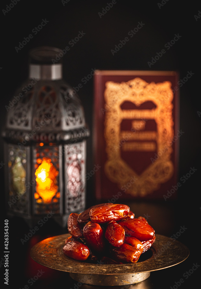 Dried dates with an open Muslim holy book Quran. The Muslim holiday of ...