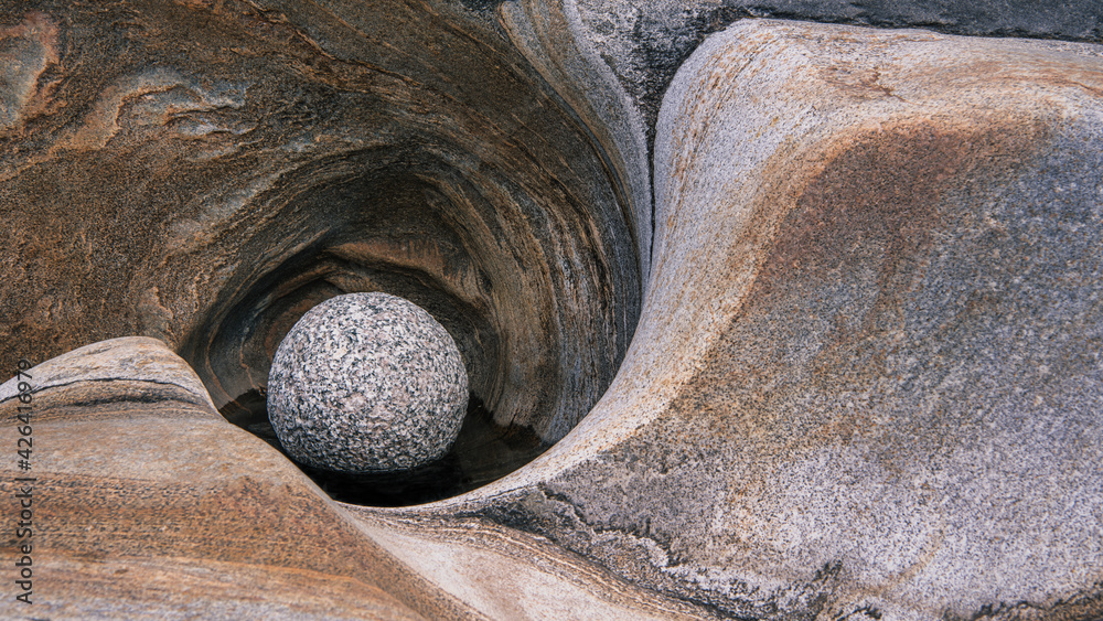 Close-up of one round stone on grey granite stone waves made by crystal ...